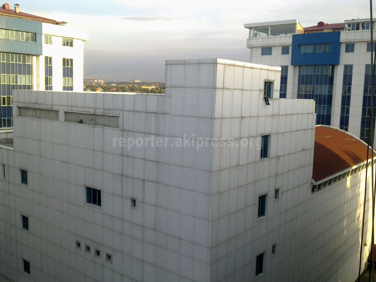 На последнем этаже Vefa Center человек сидел на окне, свесив ноги, если ...