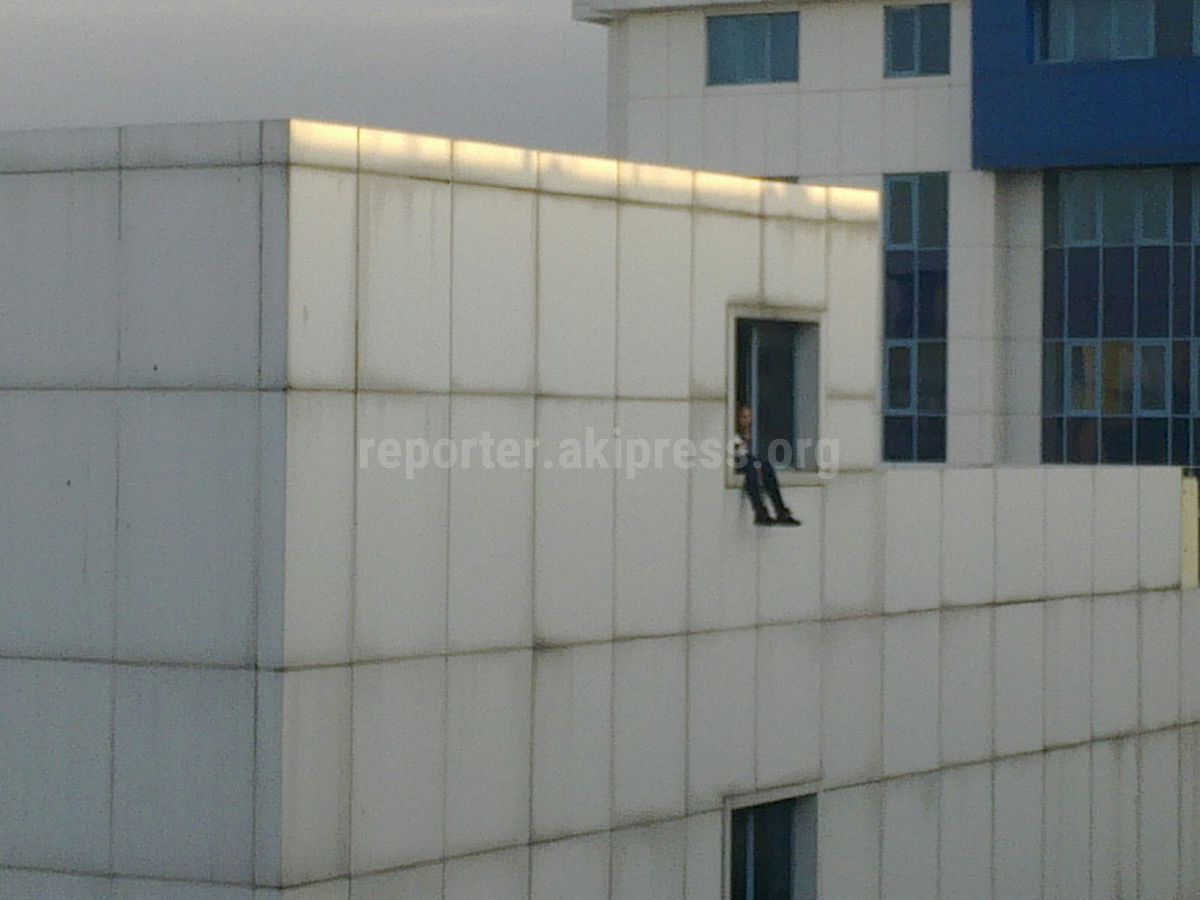 На последнем этаже Vefa Center человек сидел на окне, свесив ноги, если ...